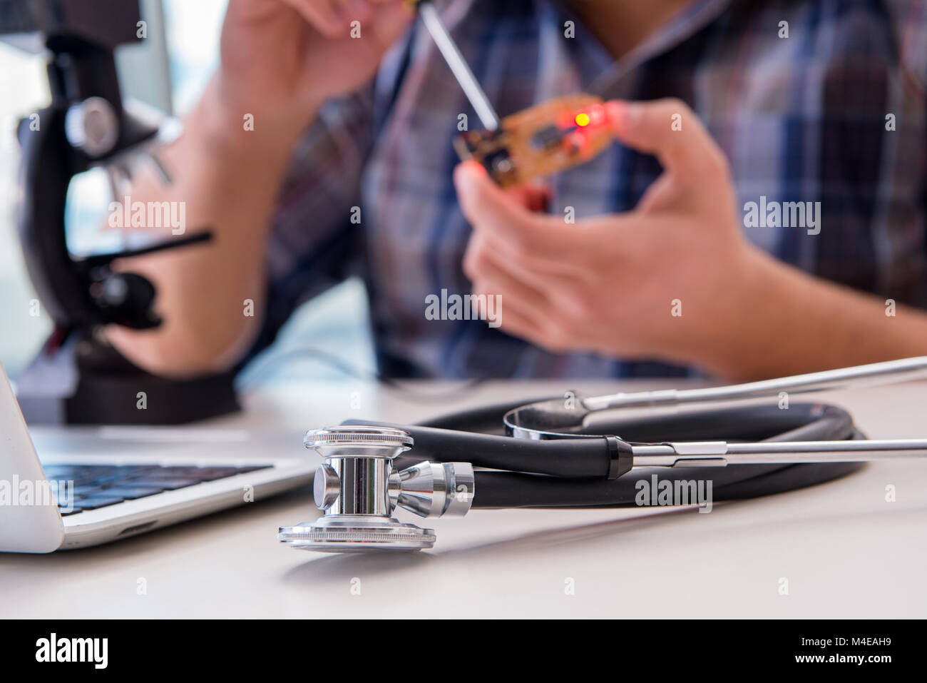High precision engineering with man working with microscope Stock Photo ...