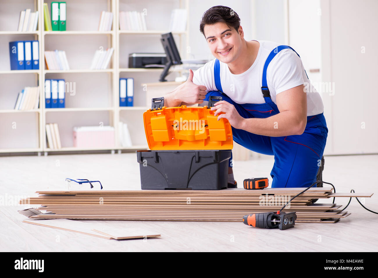 Young worker working on floor laminate tiles Stock Photo - Alamy