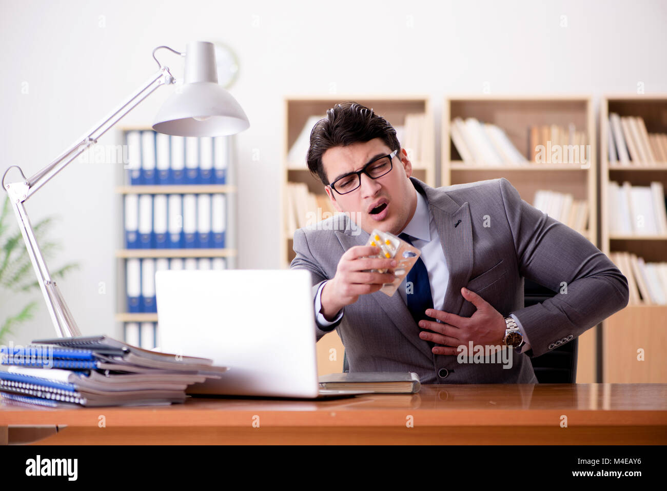 Businessman feeling pain in the office Stock Photo - Alamy