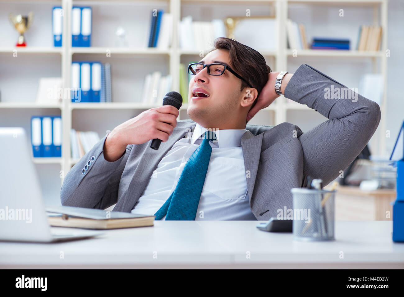 Businessman singing in the office Stock Photo - Alamy