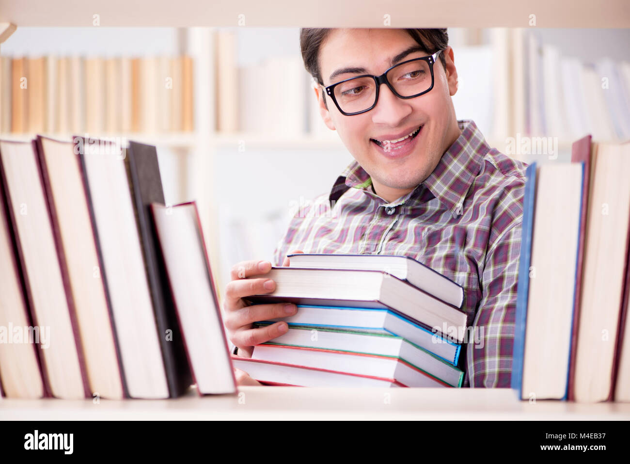 Young student looking for books in college library Stock Photo - Alamy