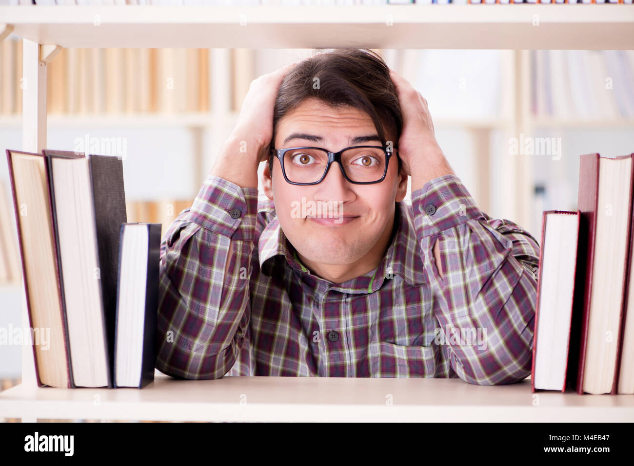 Young student looking for books in college library Stock Photo - Alamy