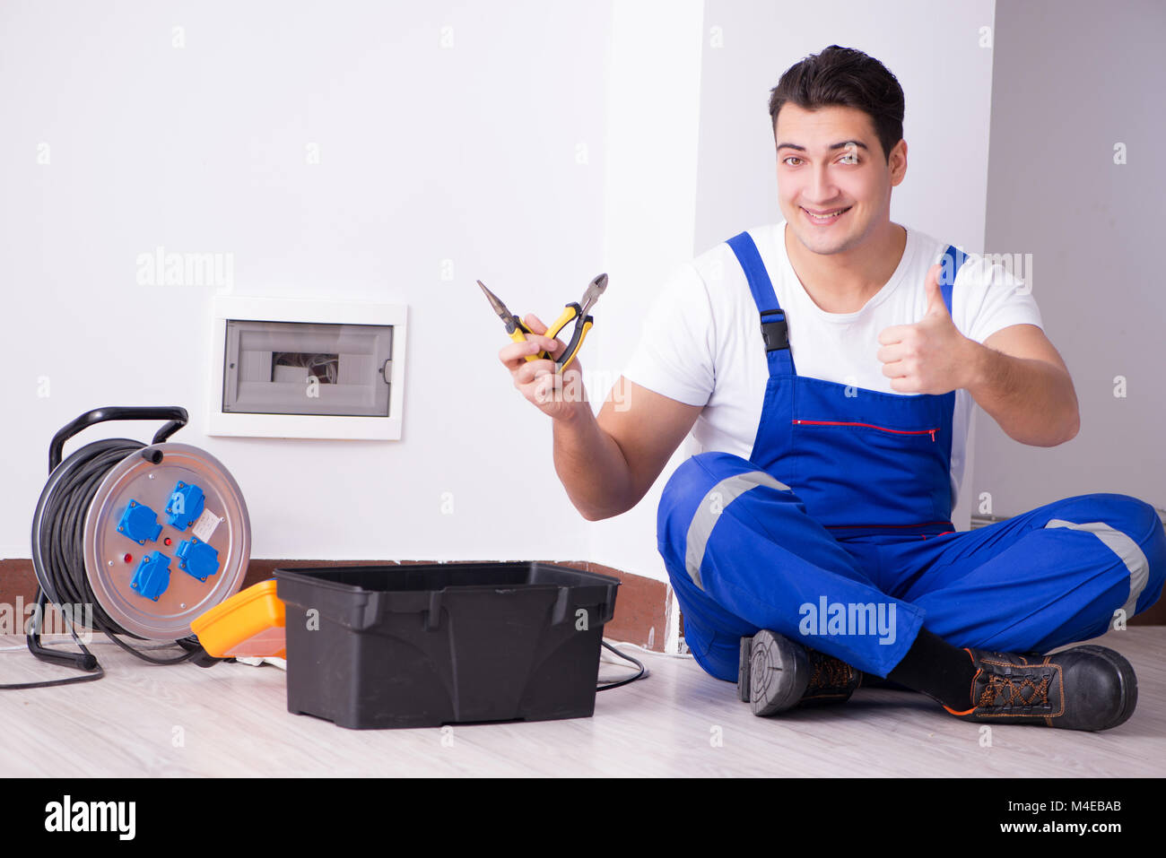 Young electrician working on socket at home Stock Photo - Alamy