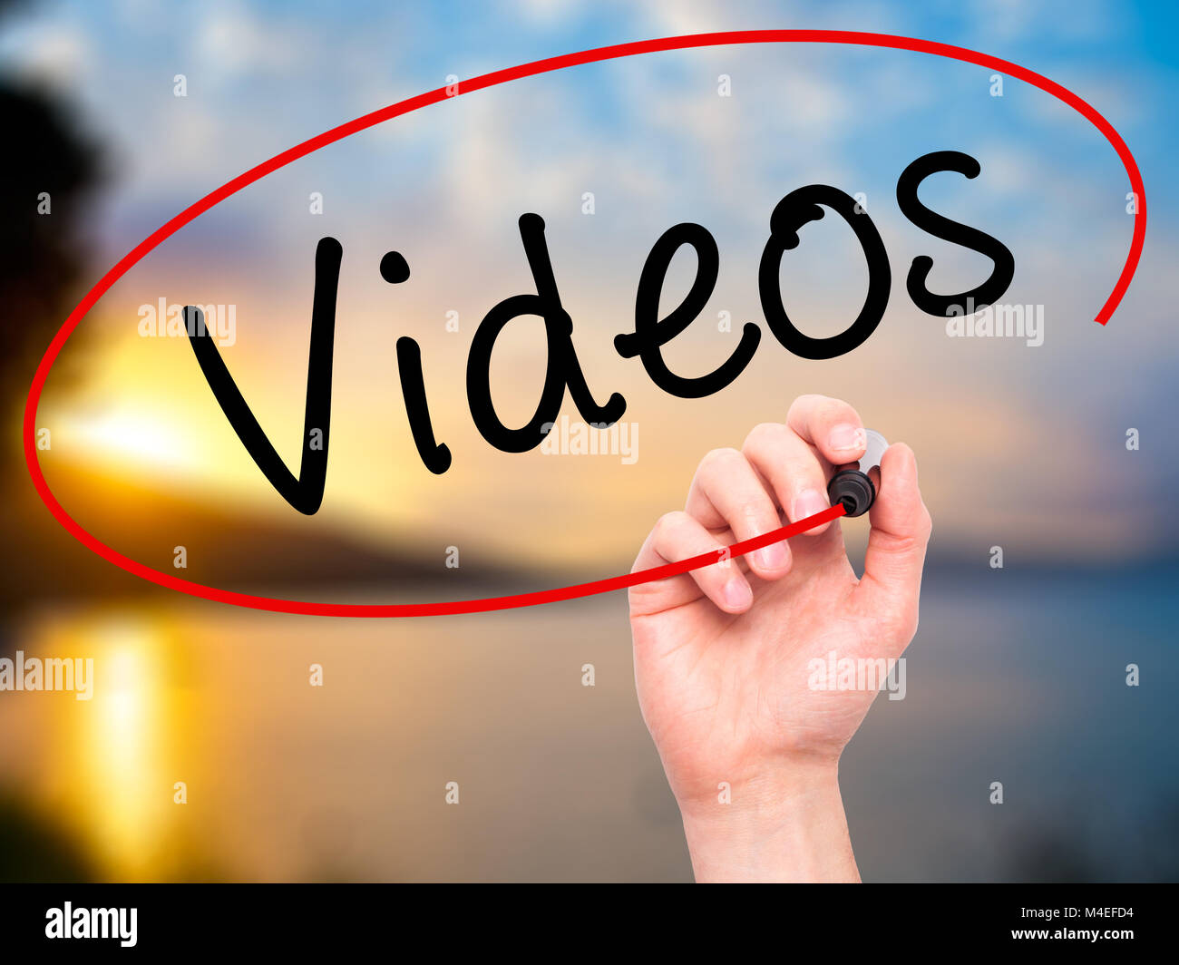 Man Hand writing Videos with black marker on visual screen Stock Photo ...