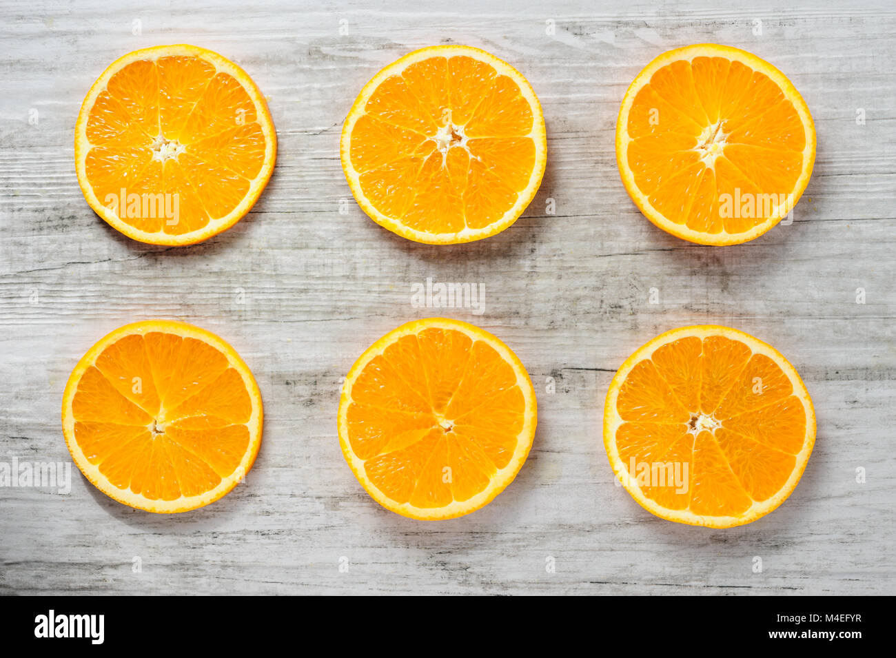 Six slices of fresh oranges on white wood background Stock Photo - Alamy