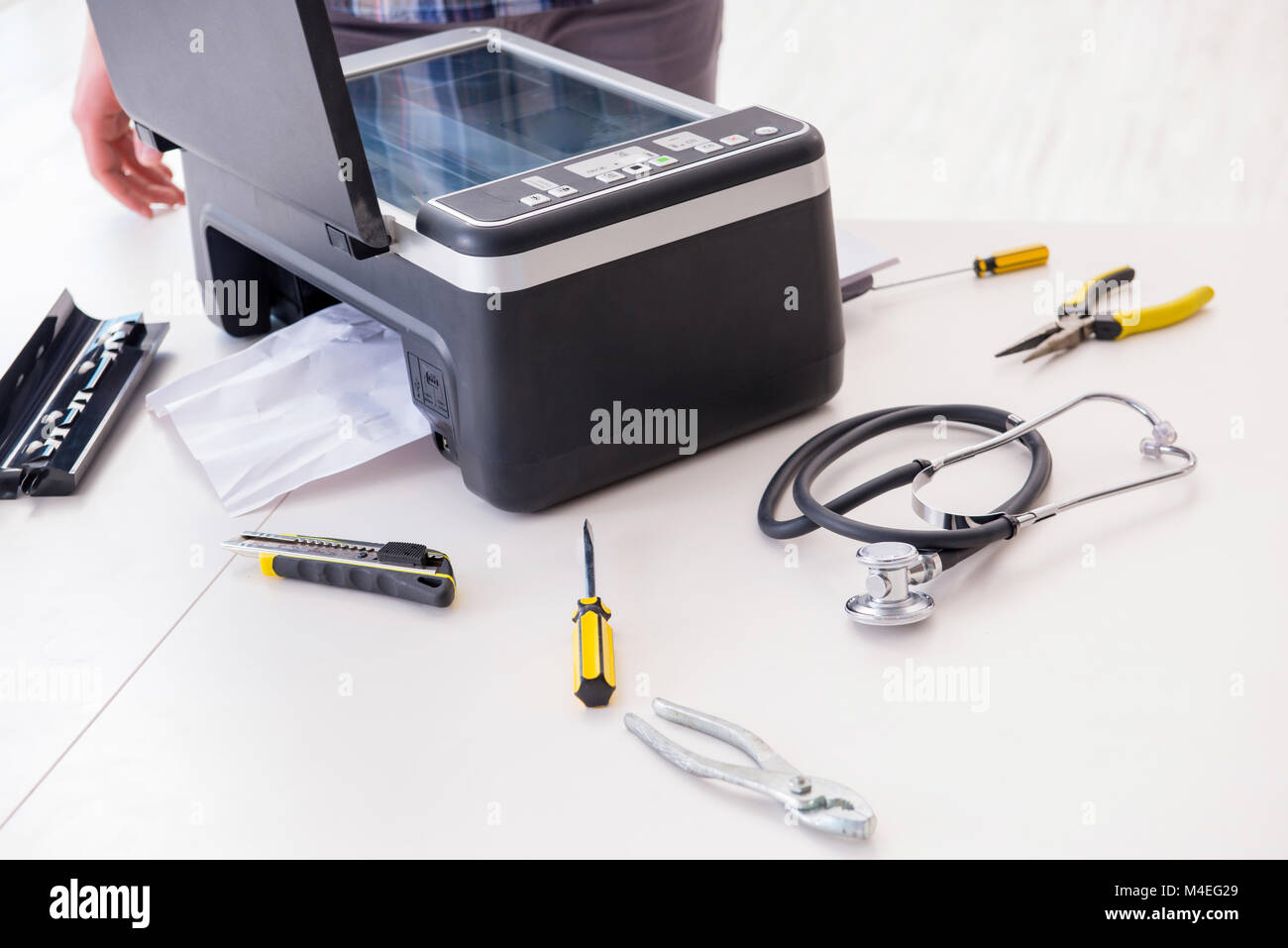 Repairman repairing broken color printer Stock Photo - Alamy