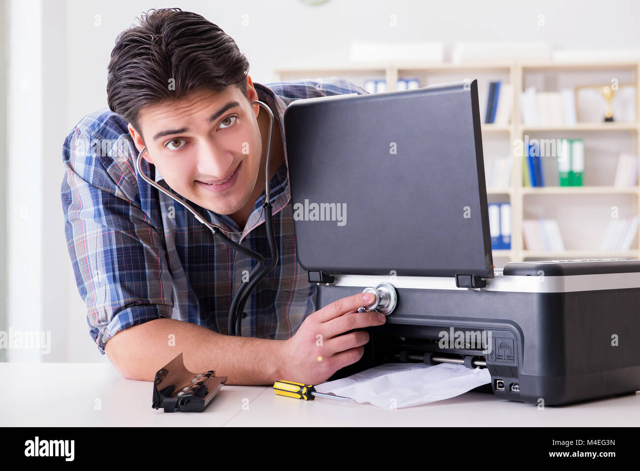 Repairman repairing broken color printer Stock Photo - Alamy
