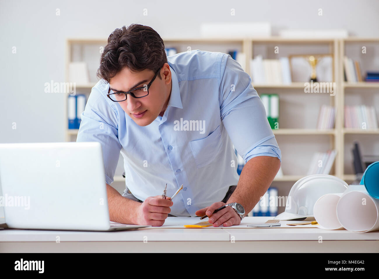 Male engineer working on drawings and blueprints Stock Photo - Alamy
