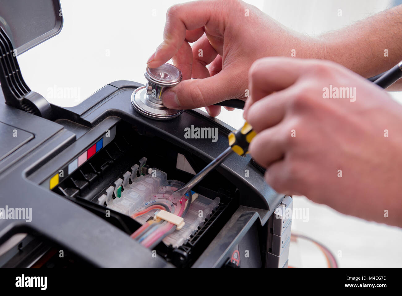 Repairman repairing broken color printer Stock Photo - Alamy