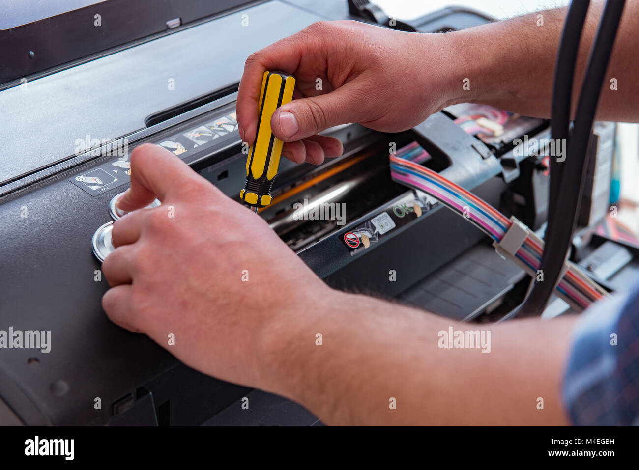 Repairman repairing broken color printer Stock Photo - Alamy