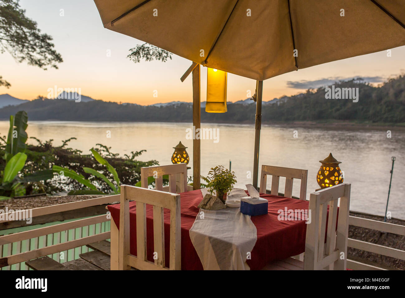 Empty table in cozy cafe overlooking the Mekong river in Luang Prabang ...