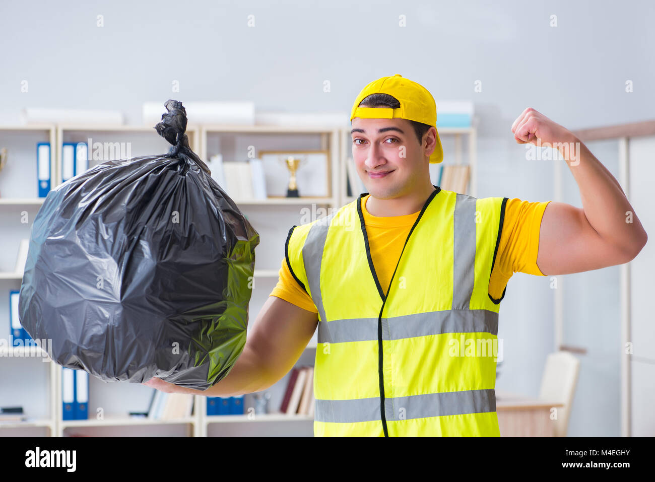 Man cleaning the office and holding garbage bag Stock Photo - Alamy