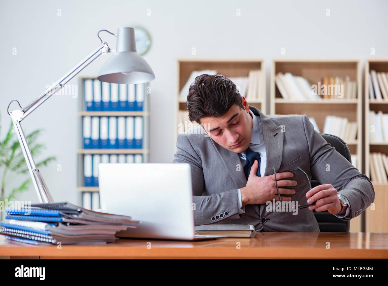Businessman feeling pain in the office Stock Photo - Alamy