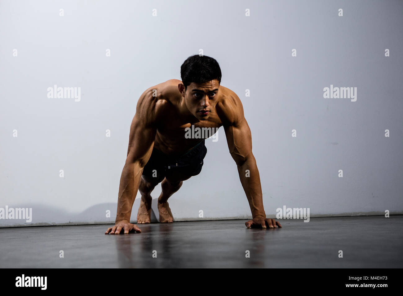 Fitness model performing push up exercise. Front facing Stock Photo - Alamy
