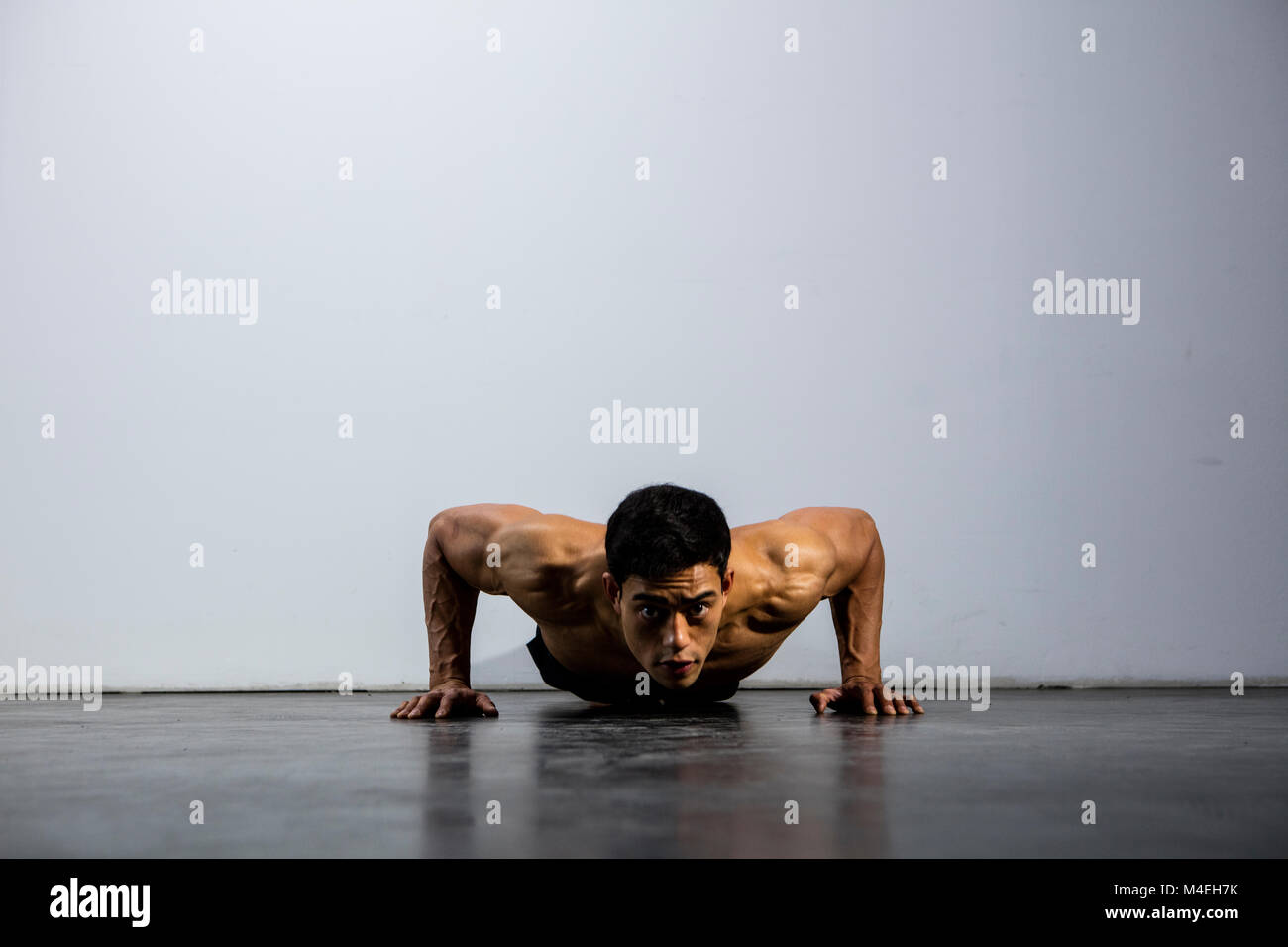 Fitness model performing push up exercise. Front facing Stock Photo - Alamy
