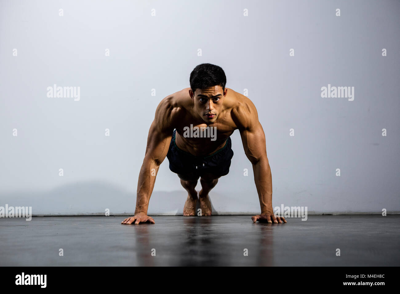 Fitness model performing push up exercise. Front facing Stock Photo - Alamy