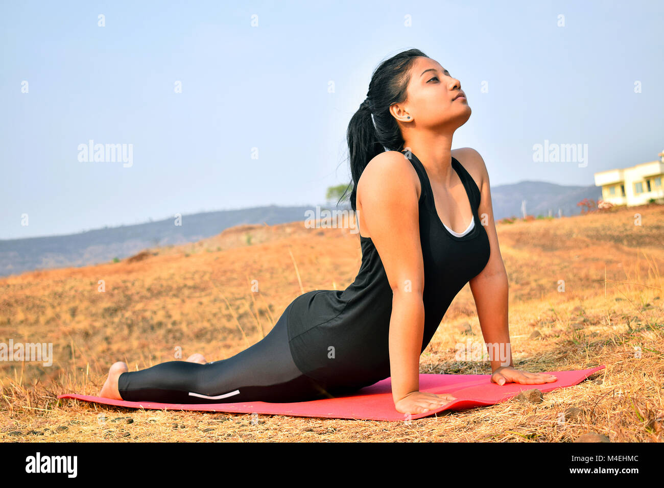 Young Indian girl doing fitness exercise - Bhujangasana or Cobra Pose ...
