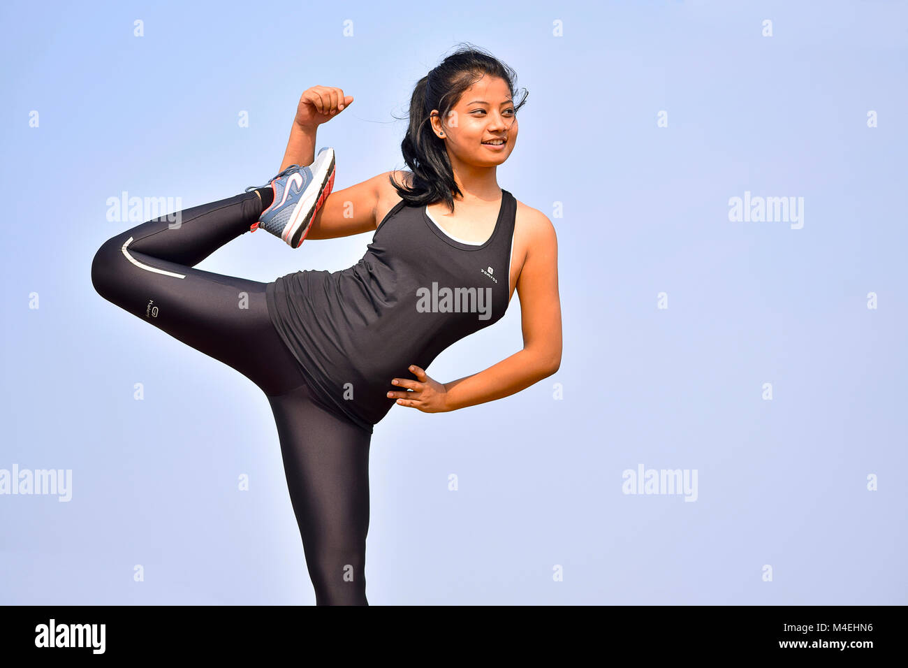 Young Indian girl doing fitness exercise. Mountain backdrop, Pune ...