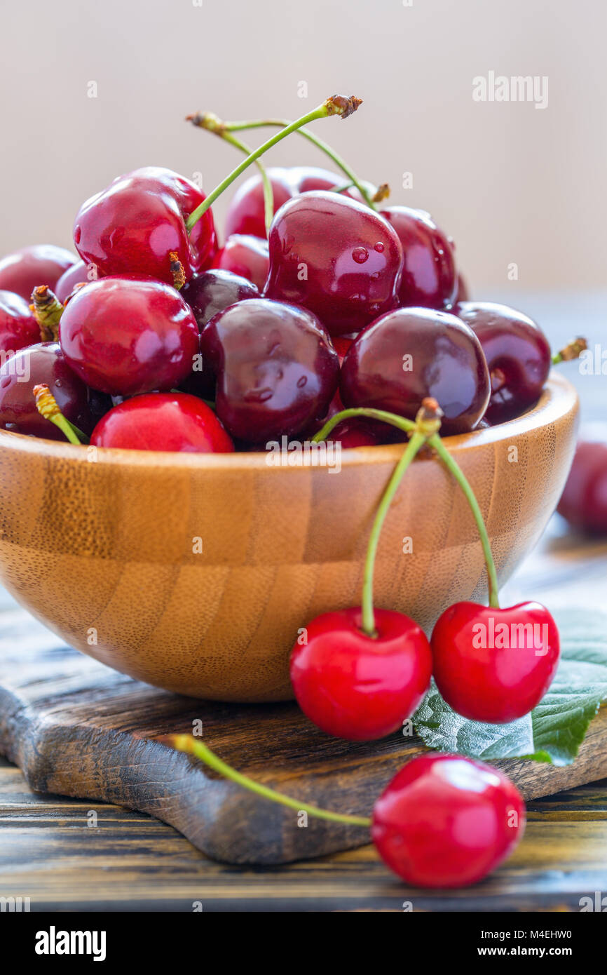 Red sweet cherries in a wooden bowl Stock Photo - Alamy