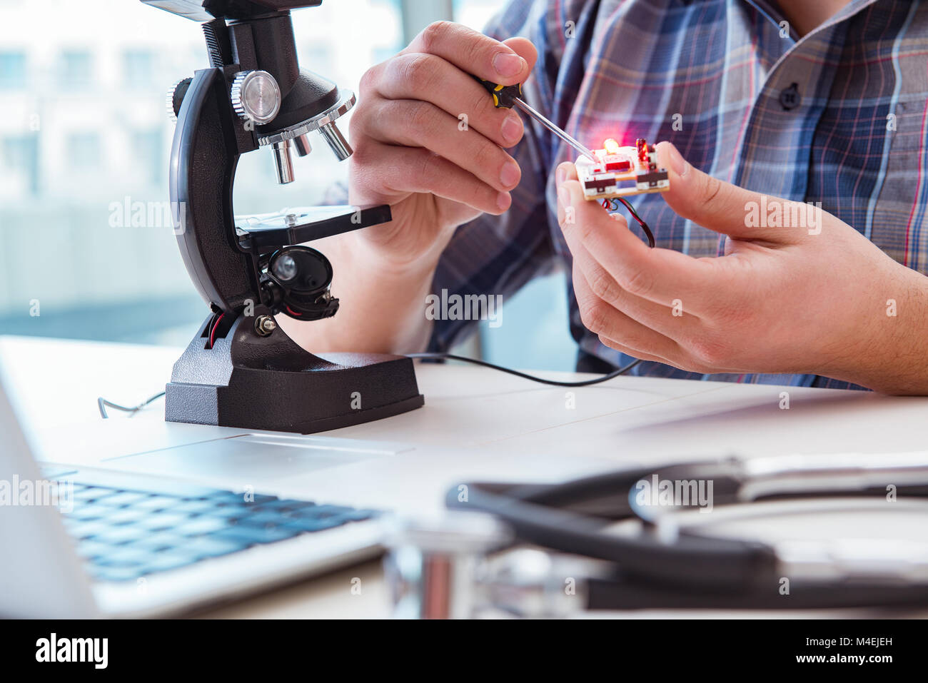 High precision engineering with man working with microscope Stock Photo ...