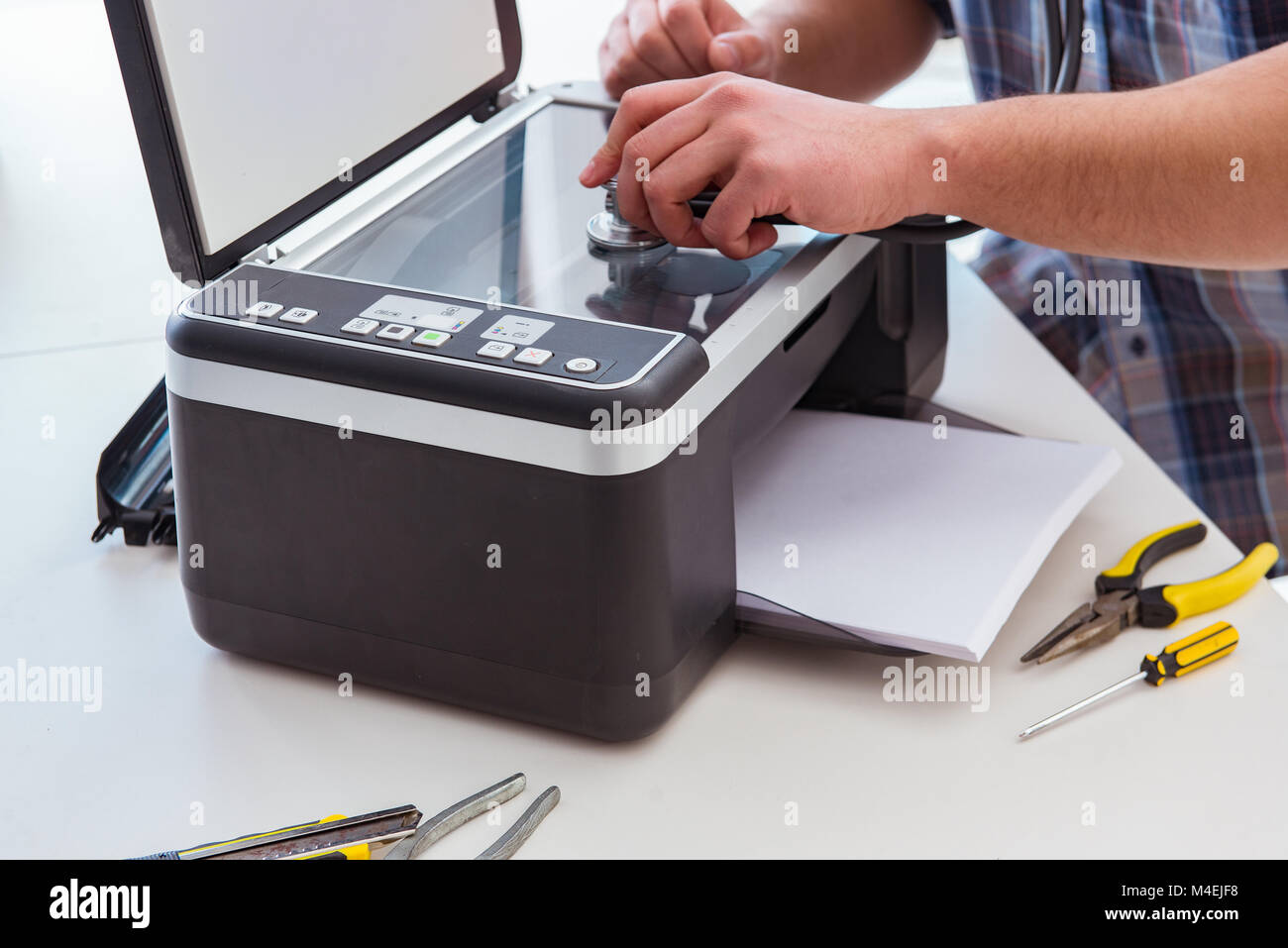 Repairman repairing broken color printer Stock Photo - Alamy