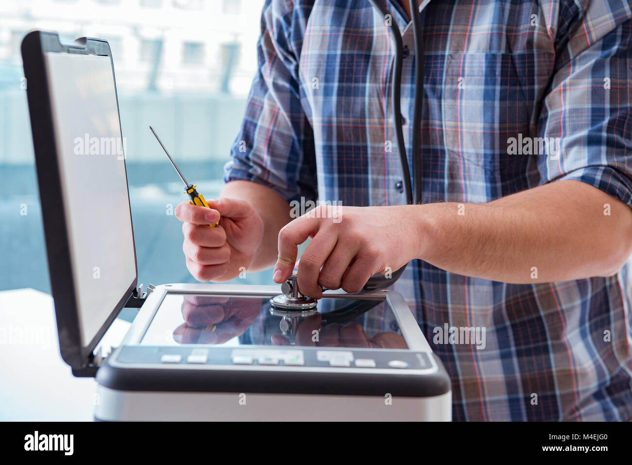 Repairman repairing broken color printer Stock Photo - Alamy