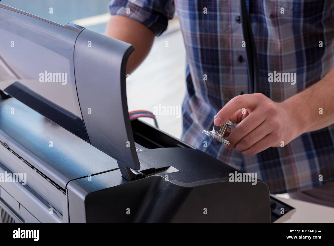 Repairman repairing broken color printer Stock Photo - Alamy