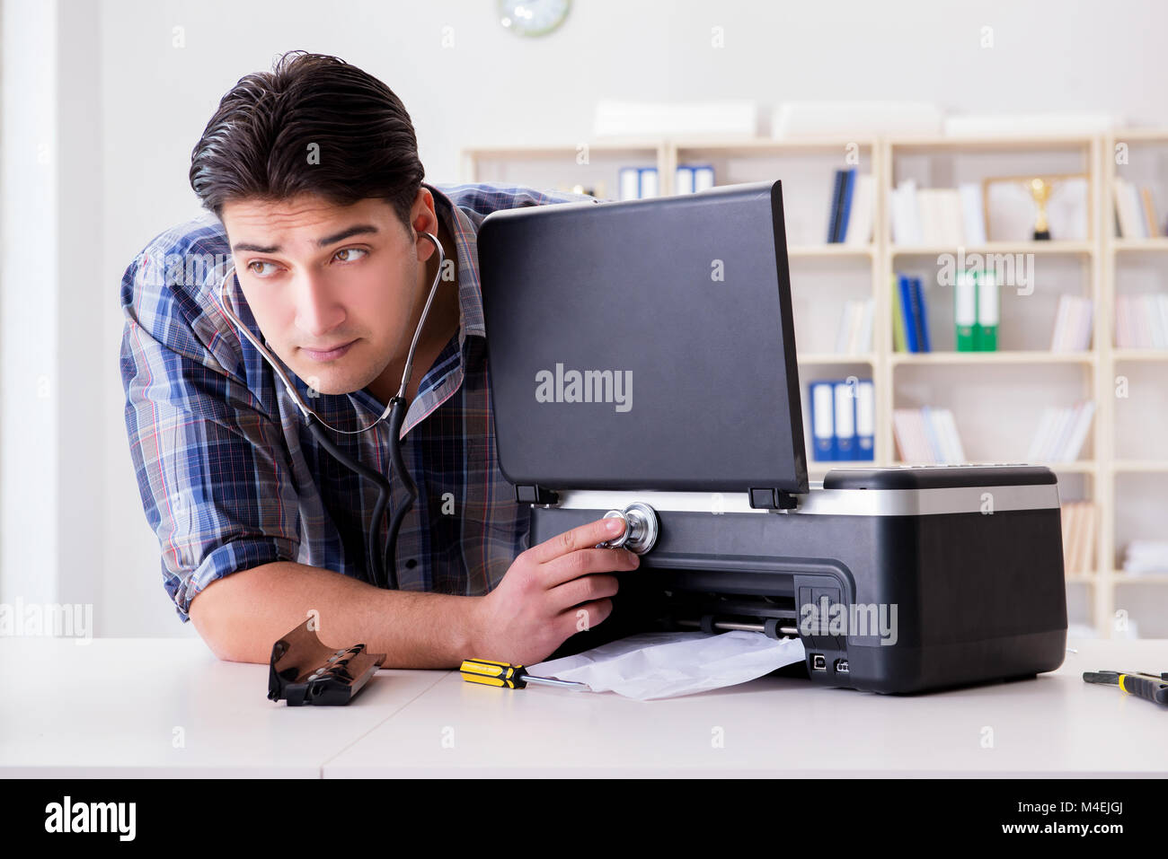 Repairman repairing broken color printer Stock Photo - Alamy