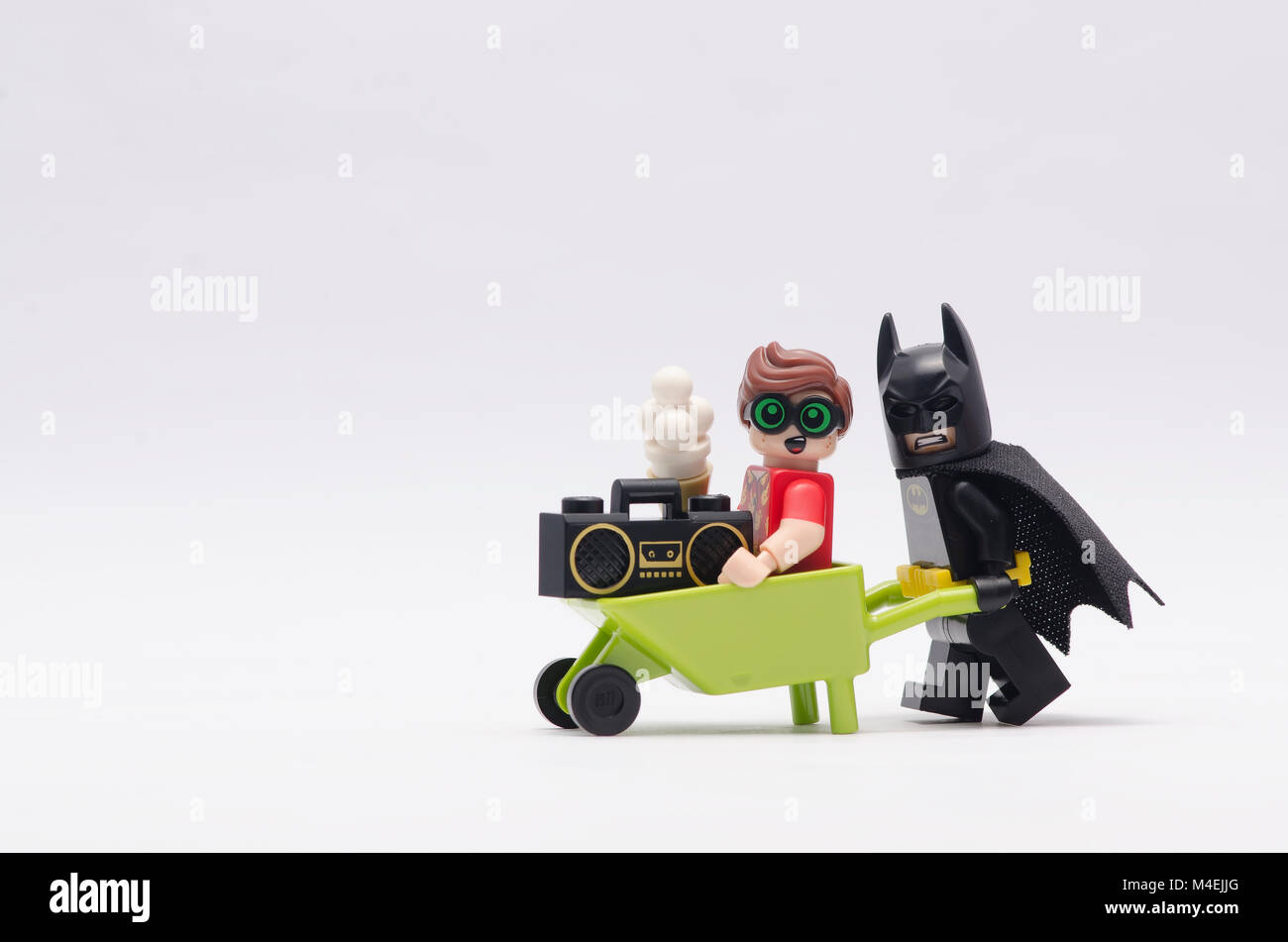 lego batman pushing wheelbarrow with robin sitting on it. isolated on ...