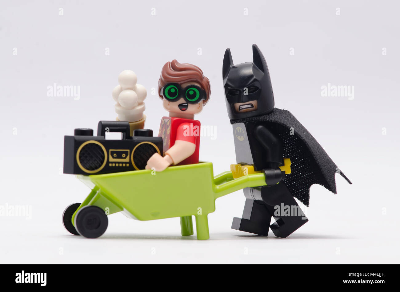 lego batman pushing wheelbarrow with robin sitting on it. isolated on ...