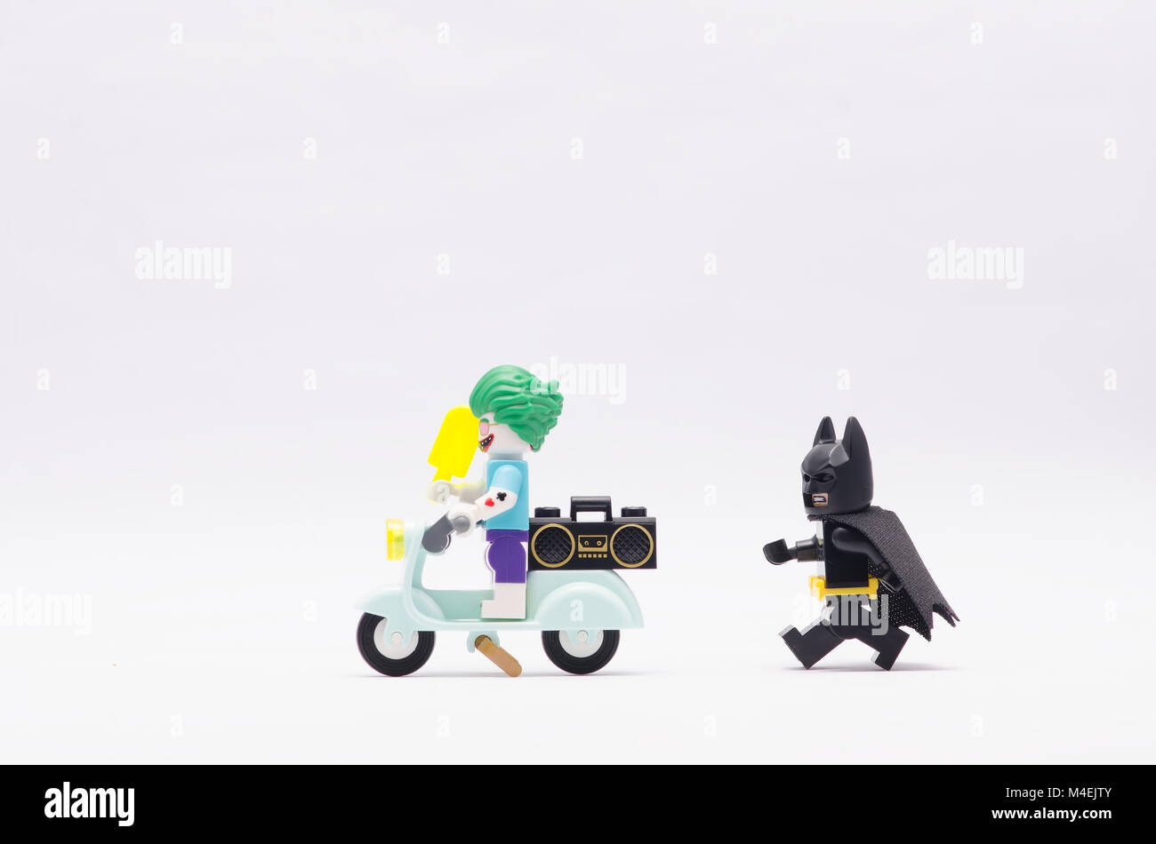 lego batman chasing joker riding a scooter. isolated on white ...