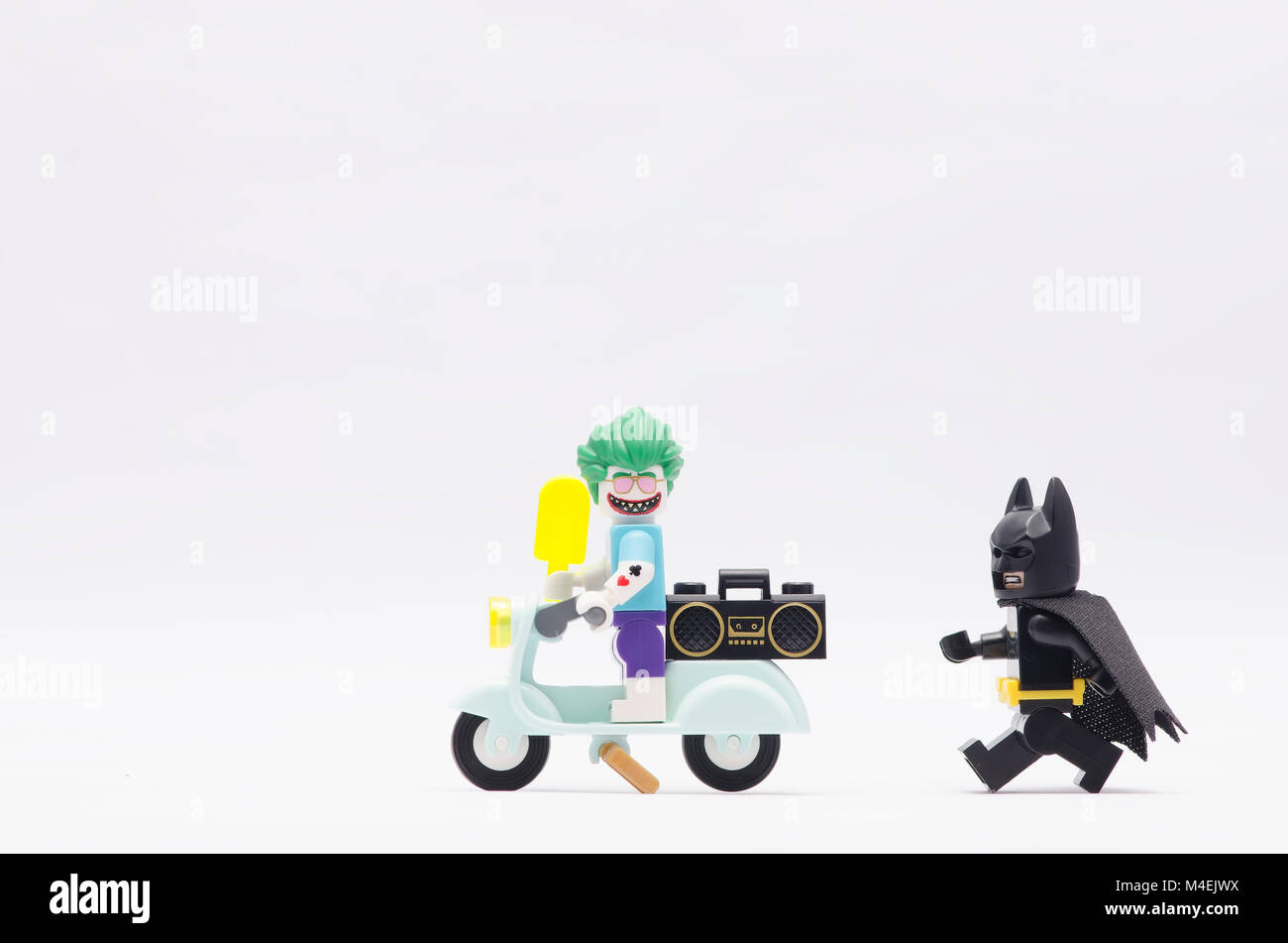 lego batman chasing joker riding a scooter. isolated on white ...
