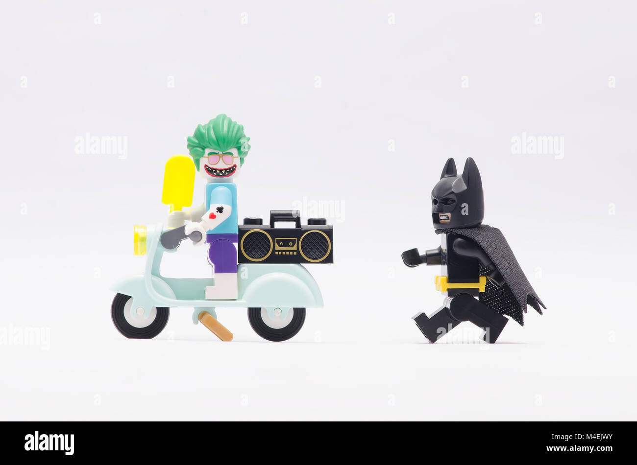 lego batman chasing joker riding a scooter. isolated on white ...