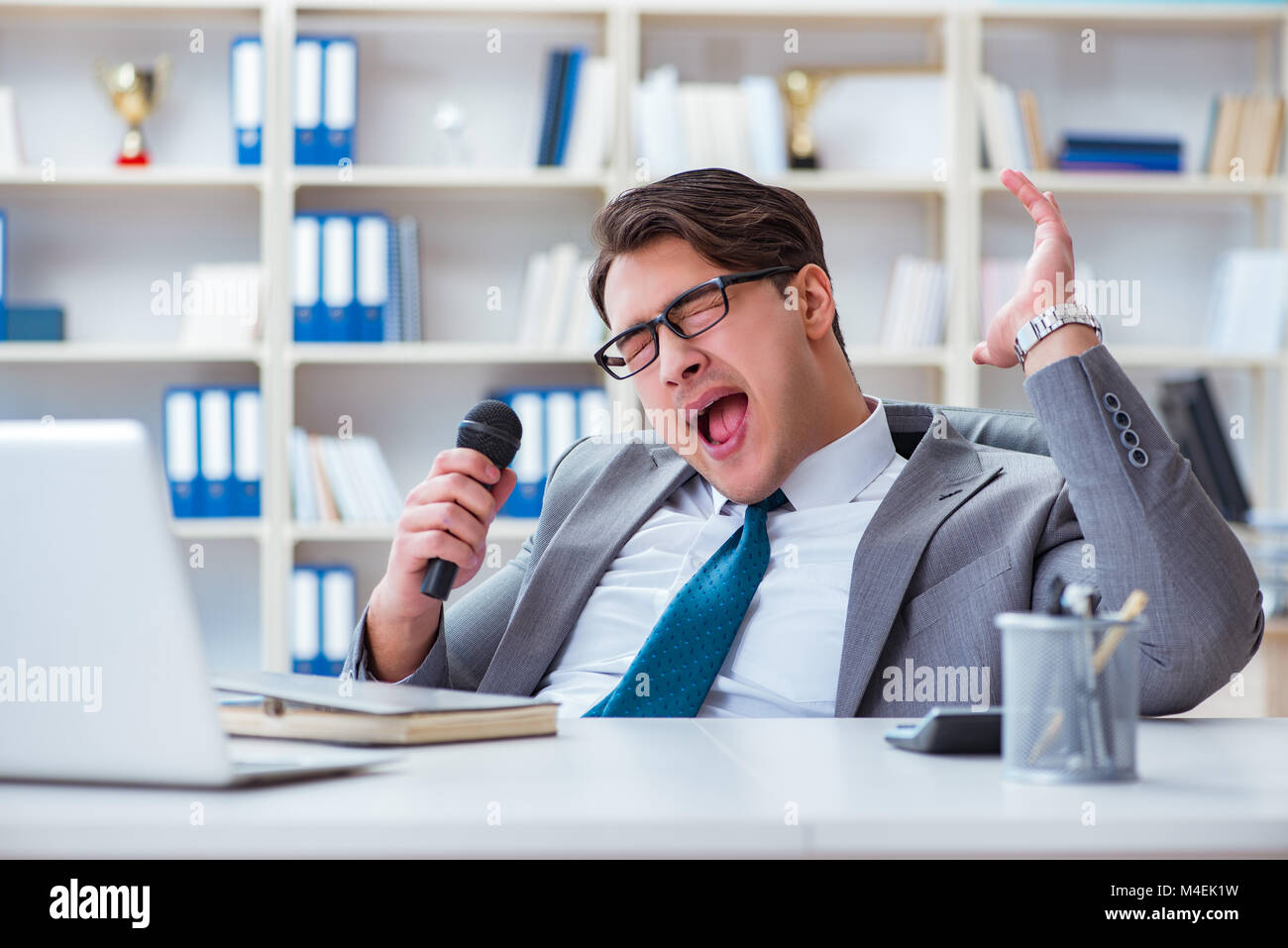 Businessman singing in the office Stock Photo - Alamy
