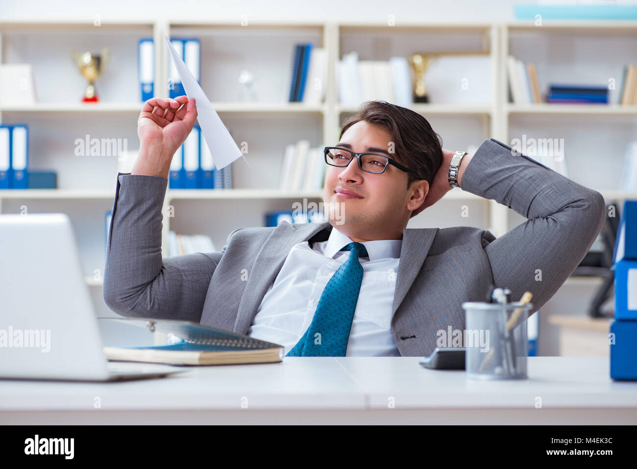 Businessman with paper airplane in office Stock Photo - Alamy