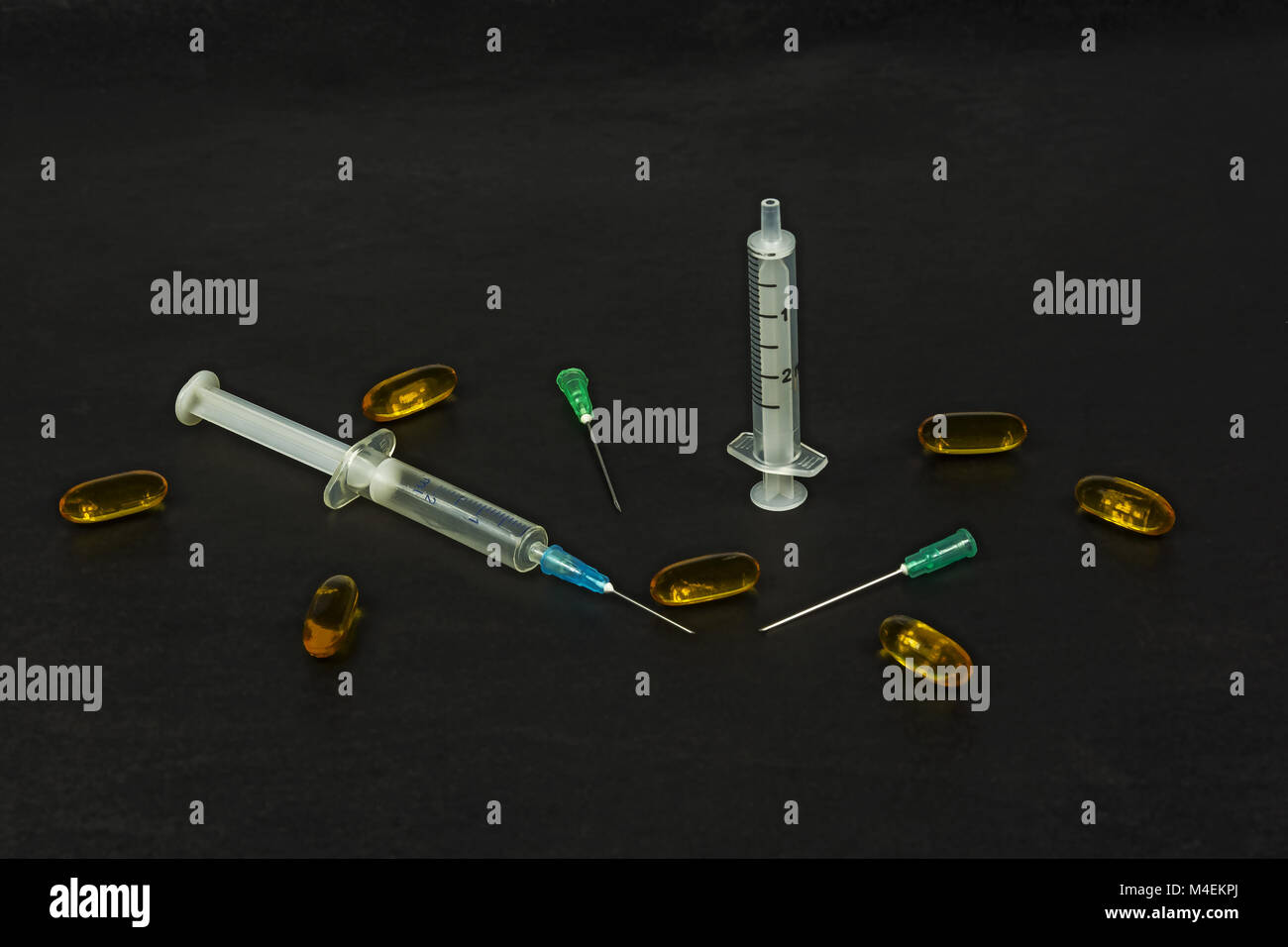 Medical syringe, needles and pills on a black background Stock Photo ...