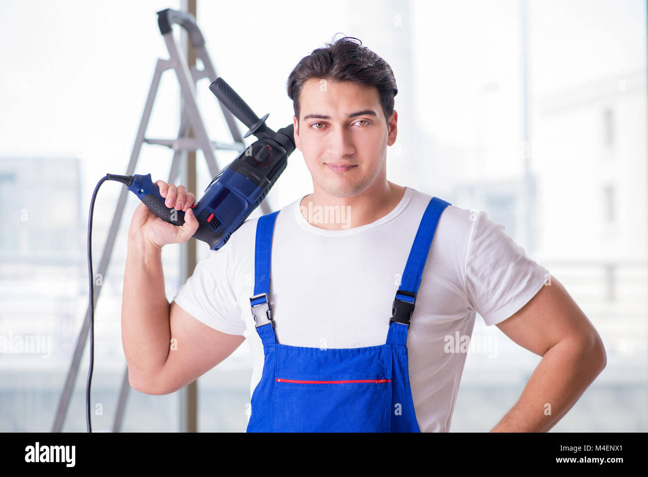 Young worker with hand drill Stock Photo - Alamy