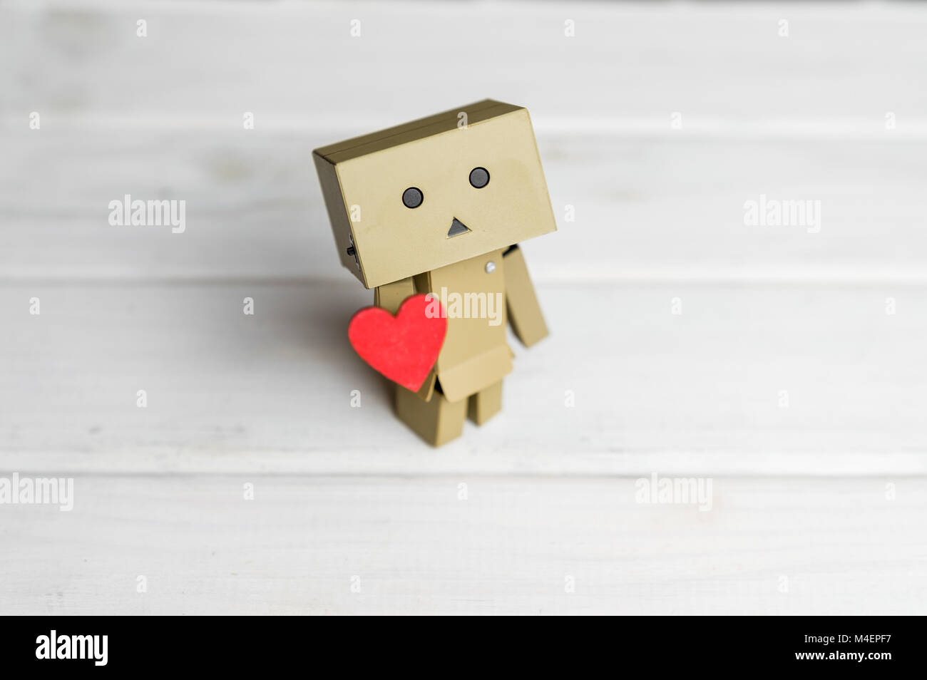 Little robot character Danbo standing on wooden floor with red heart in ...