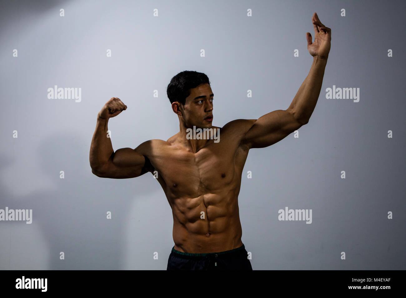 An Asian fitness model displaying his upper body physique. Medium shot ...