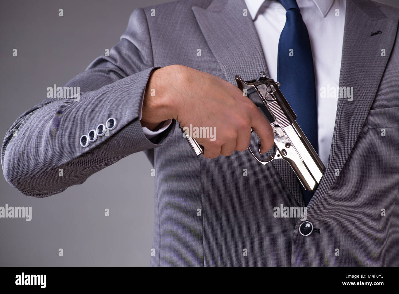 Businessman pulling the gun out of pocket Stock Photo - Alamy