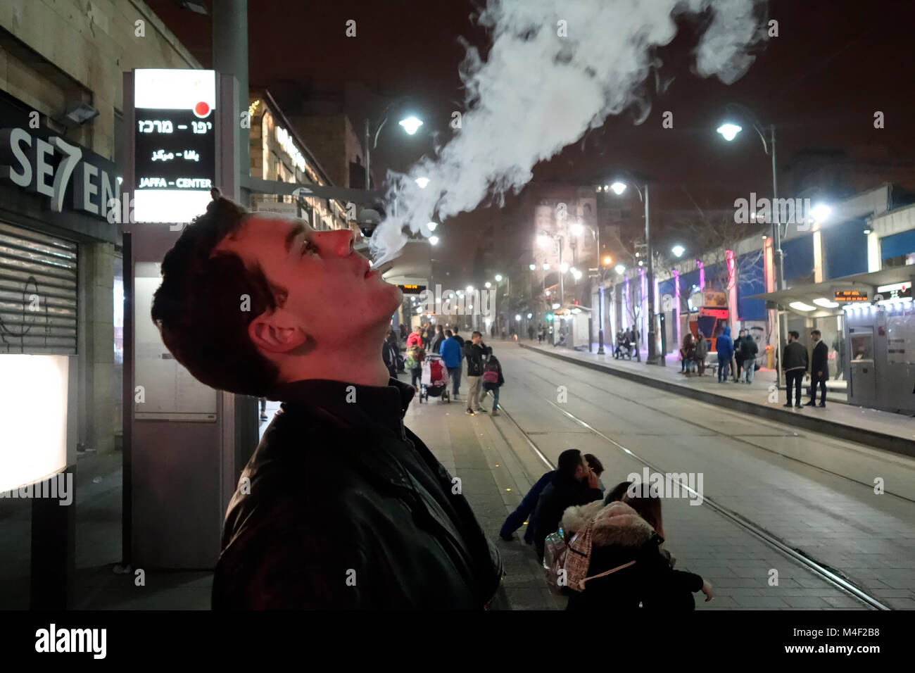 Young Israeli man vaping electronic cigarette in Jaffa road West ...