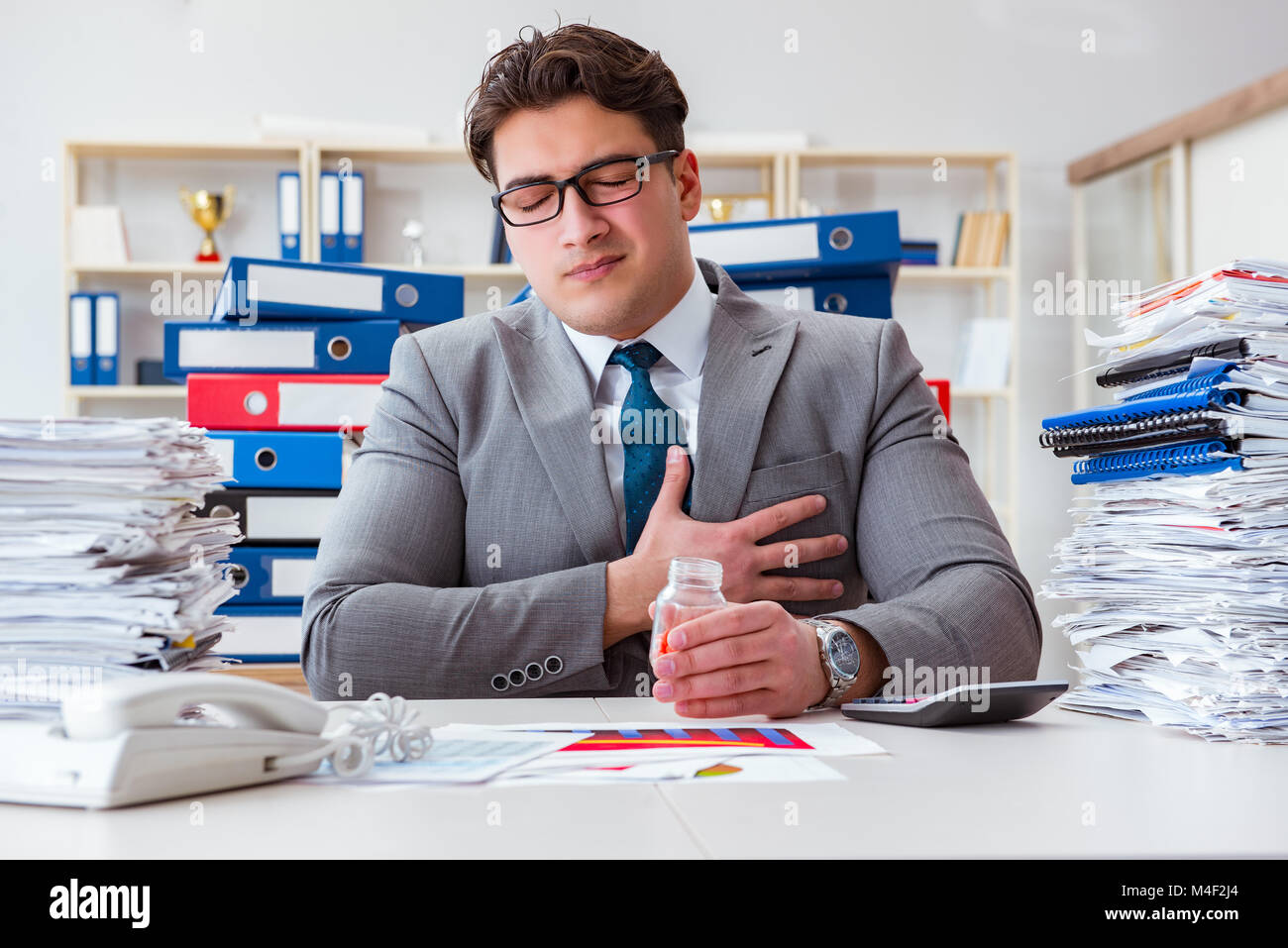 Businessman taking pills to cope with stress Stock Photo - Alamy