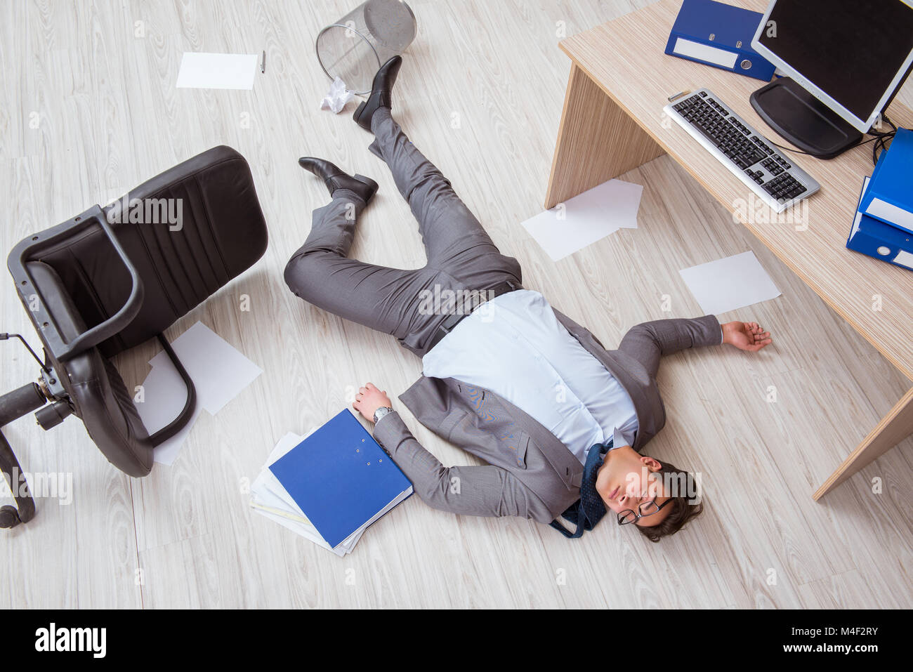 Businessman dead on the office floor Stock Photo - Alamy
