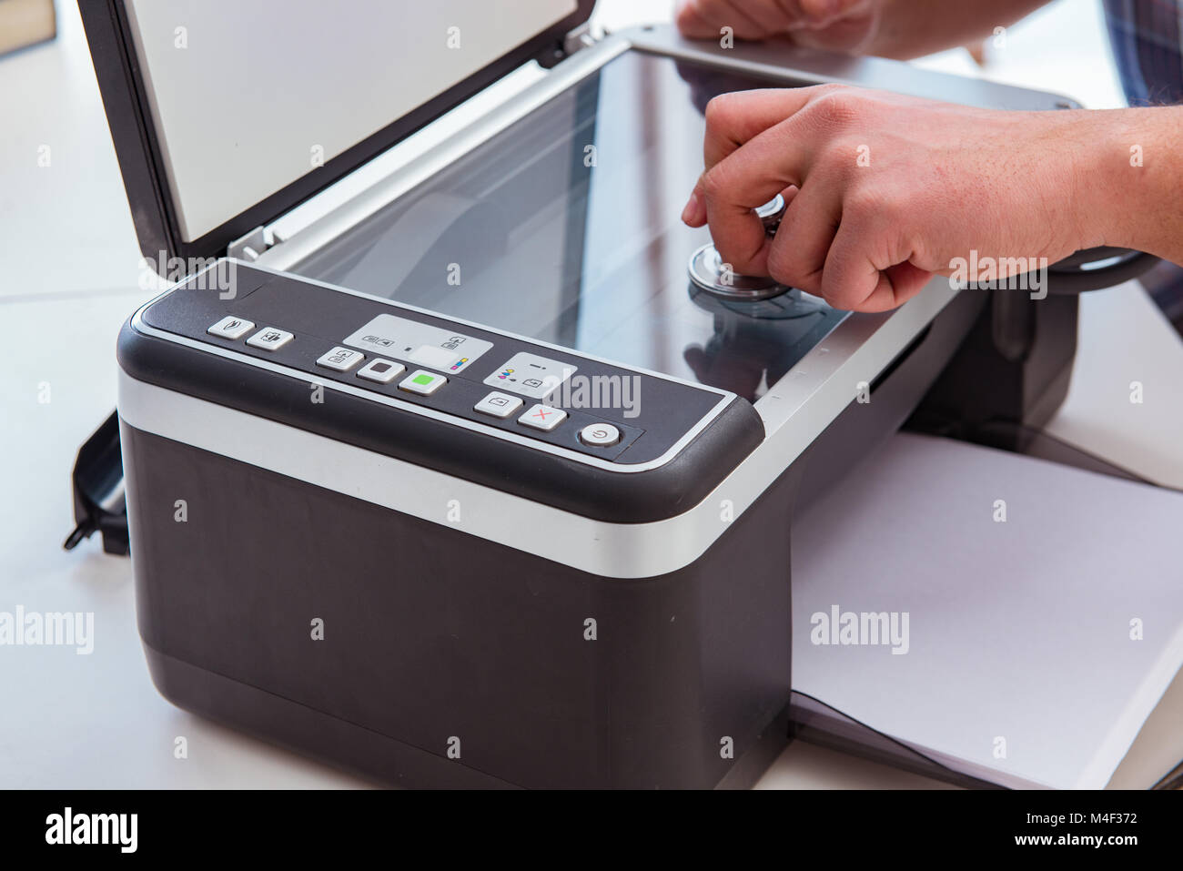 Repairman repairing broken color printer Stock Photo - Alamy