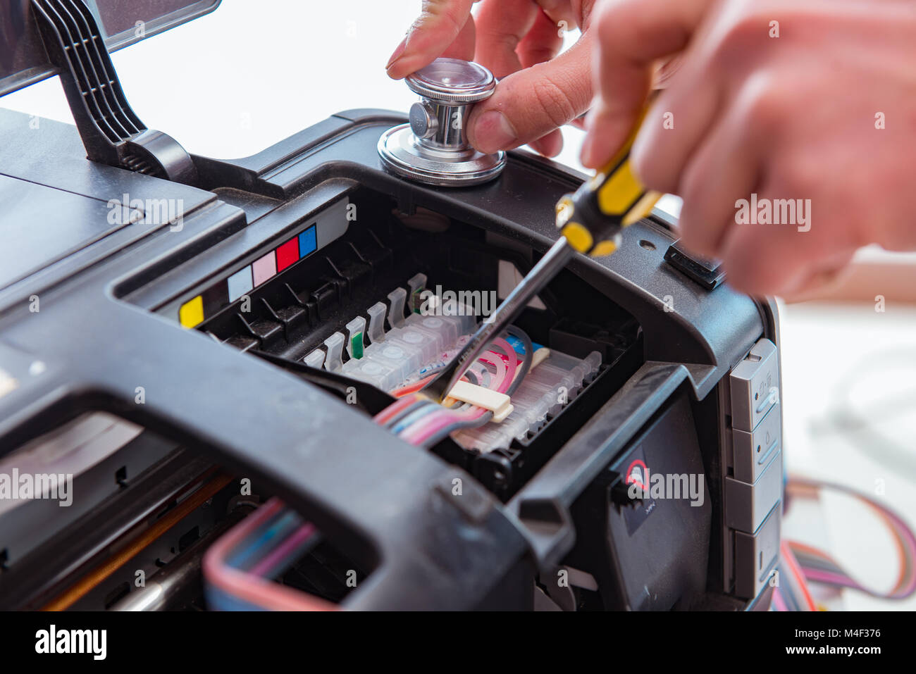Repairman repairing broken color printer Stock Photo - Alamy