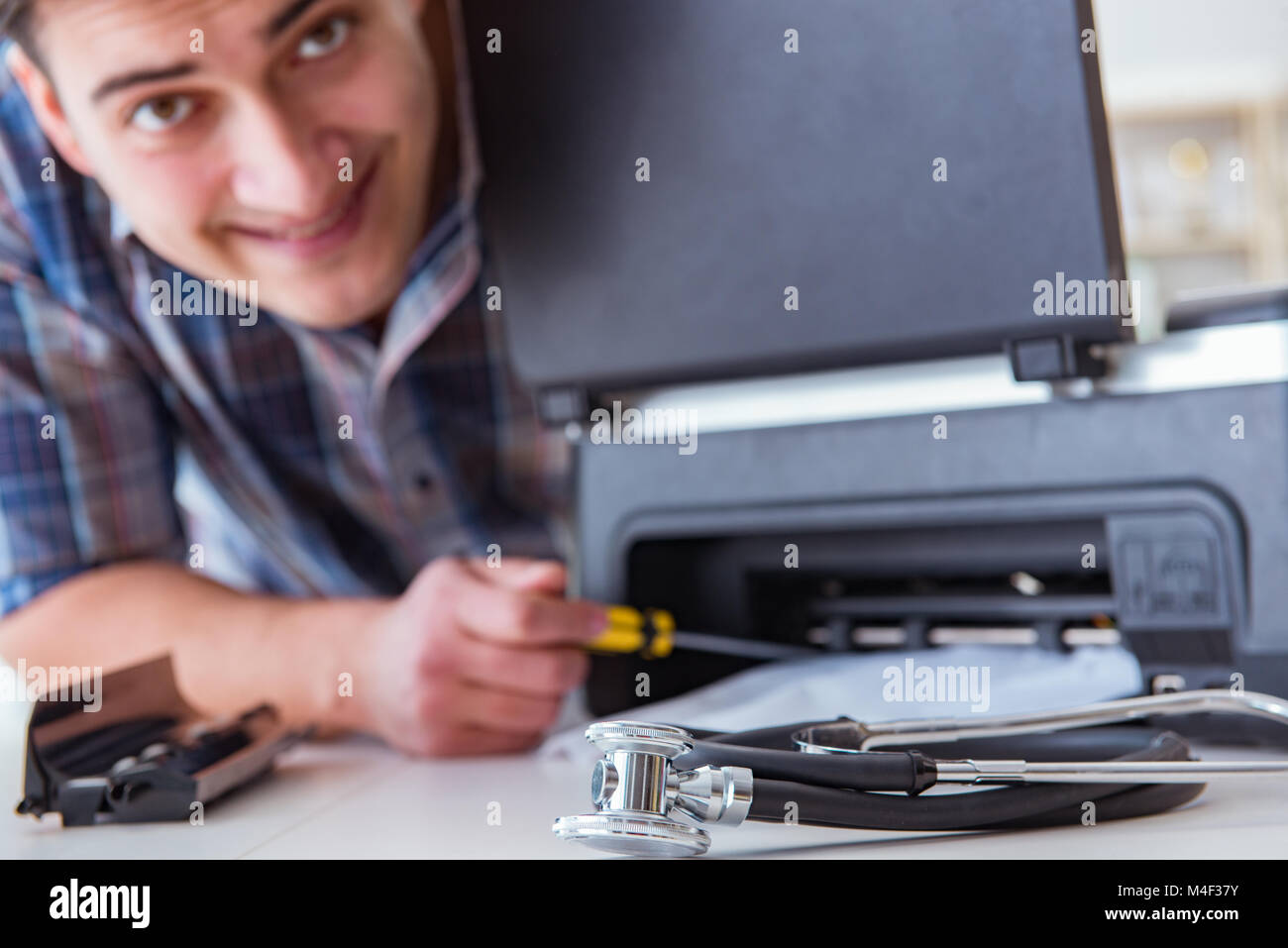 Repairman repairing broken color printer Stock Photo - Alamy