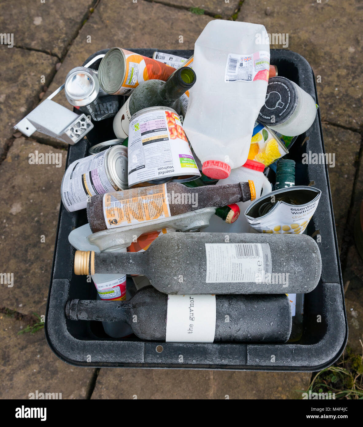 Frost-covered recycling box of glass, plastic and metal awaiting ...