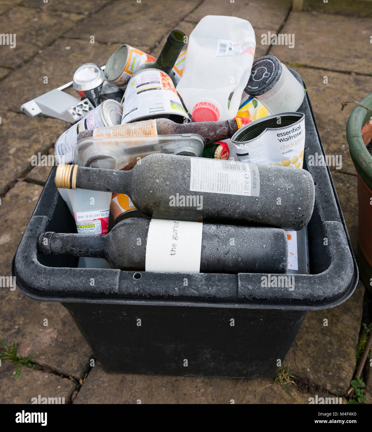 Frost-covered recycling box of glass, plastic and metal awaiting ...