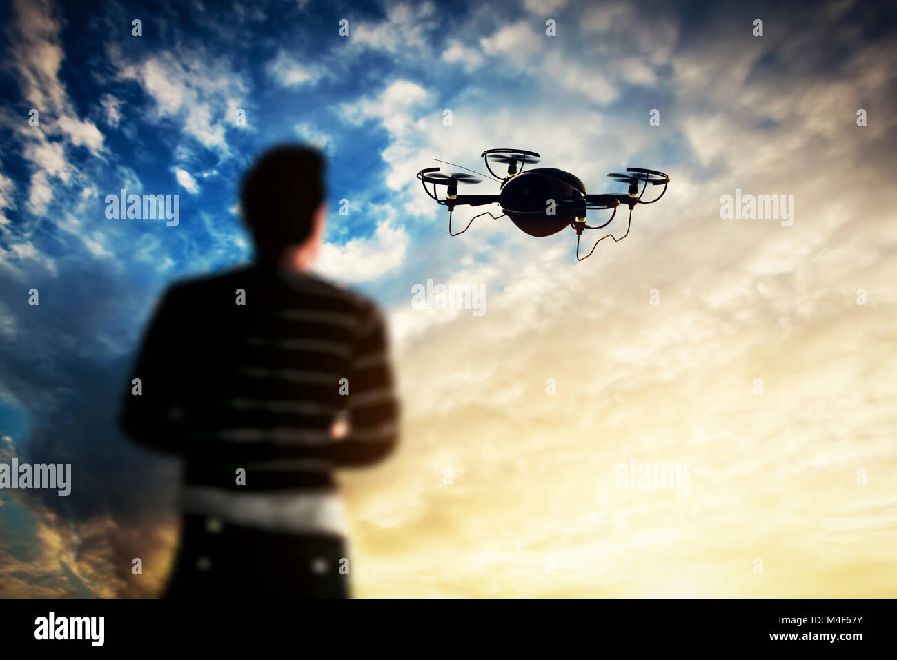 Man operating a drone at sunset Stock Photo - Alamy