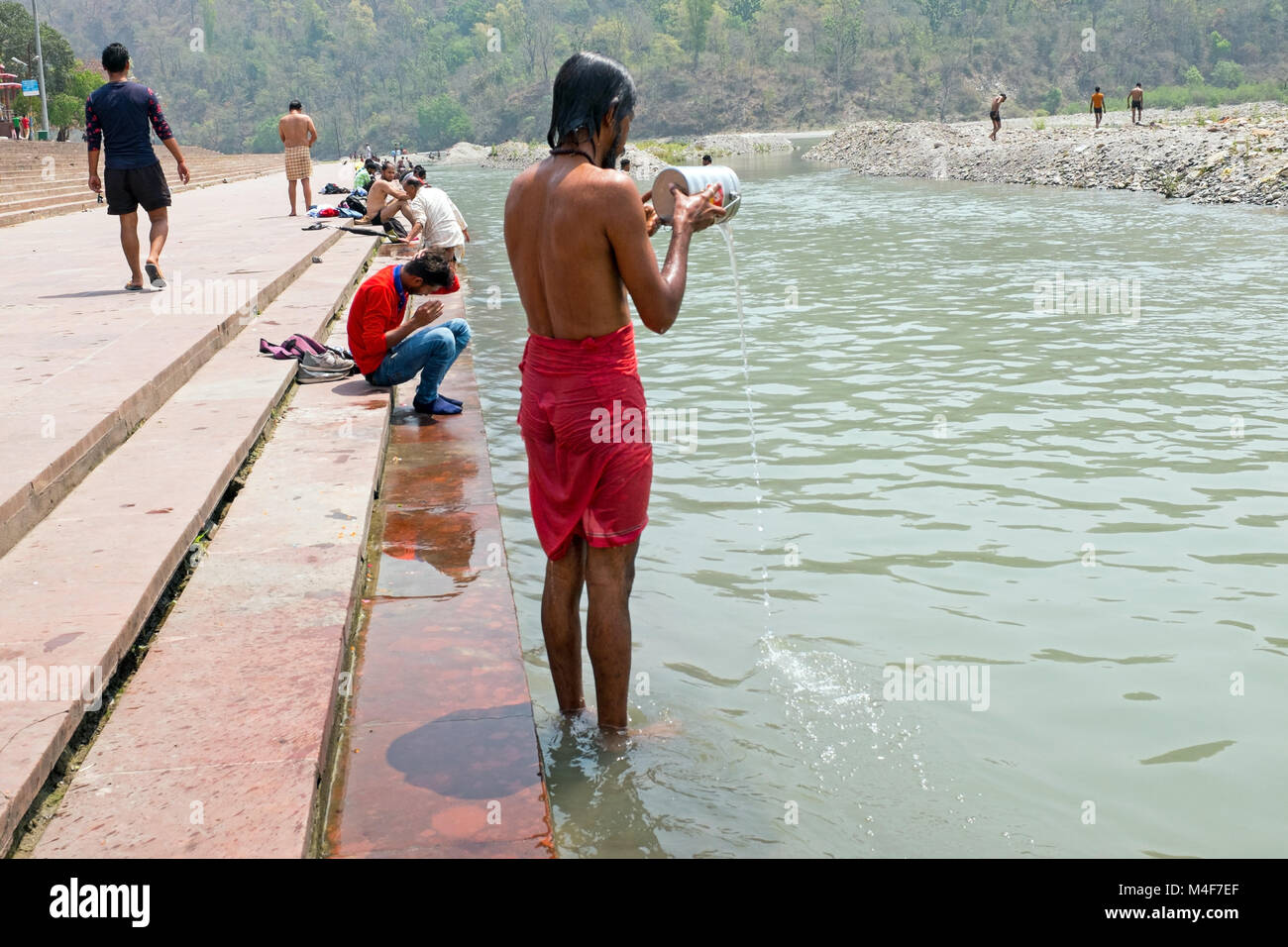 RISHIKESH, INDIA - APRIL 17, 2017: A Hindu sadhu taking a bath at the ...